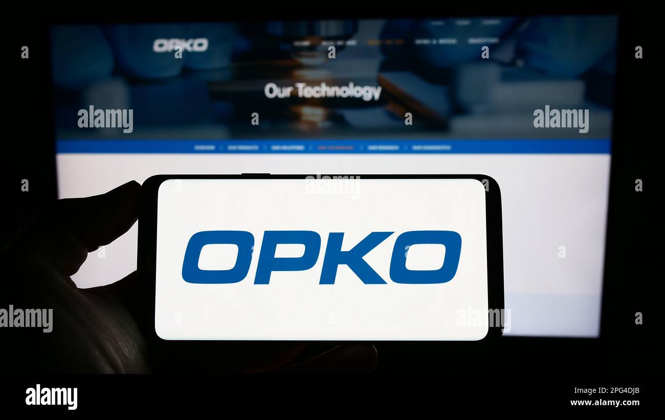 Person holding cellphone with logo of US medical company OPKO Health ...