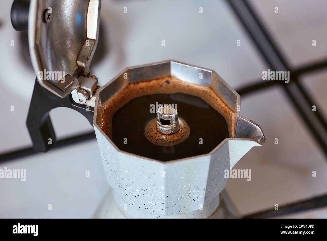 A geyser coffee maker on a gas stove produces a portion of coffee Stock ...