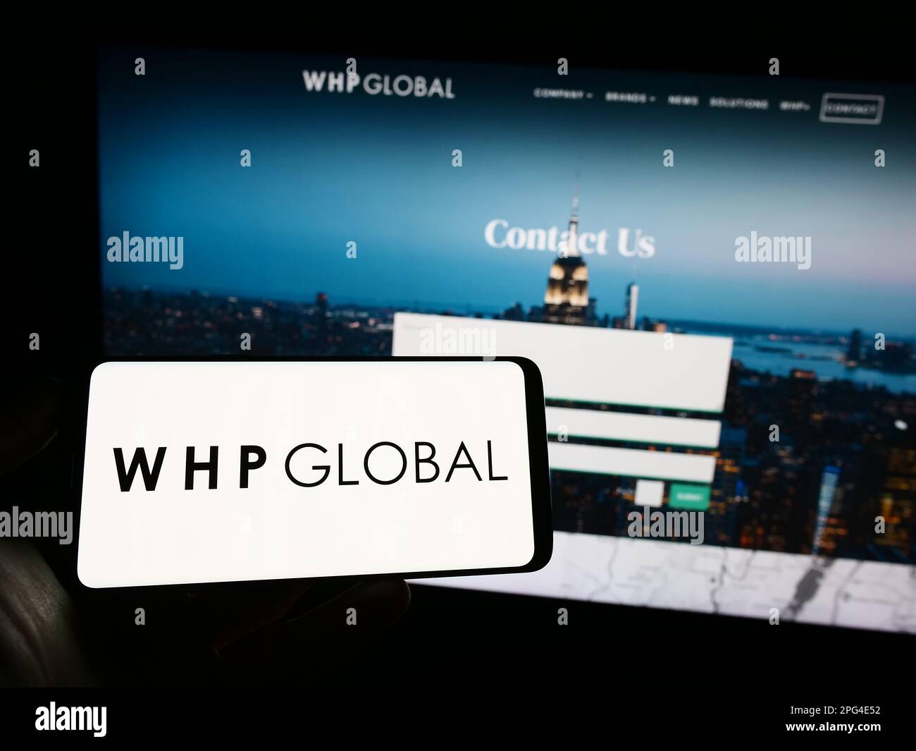 Person holding cellphone with logo of US investment company WHP Global ...