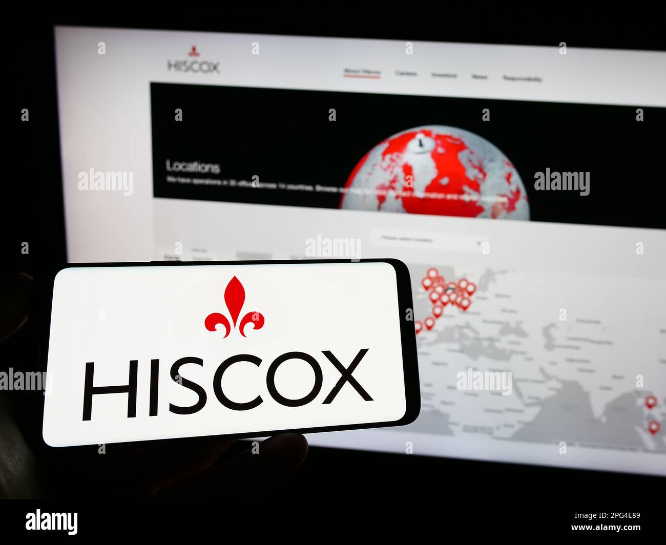 Person holding mobile phone with logo of insurance company Hiscox Ltd ...