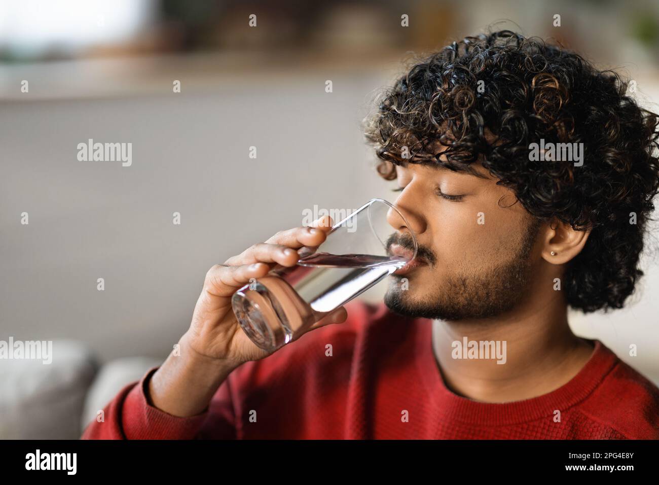 Young Handsome Indian Guy Drinking Water From Glass At Home Stock Photo ...