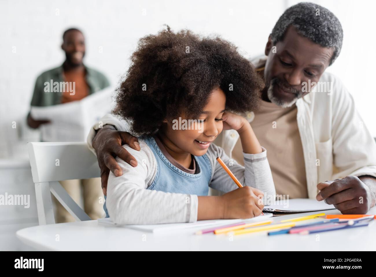bearded african american grandpa hugging happy granddaughter drawing on ...