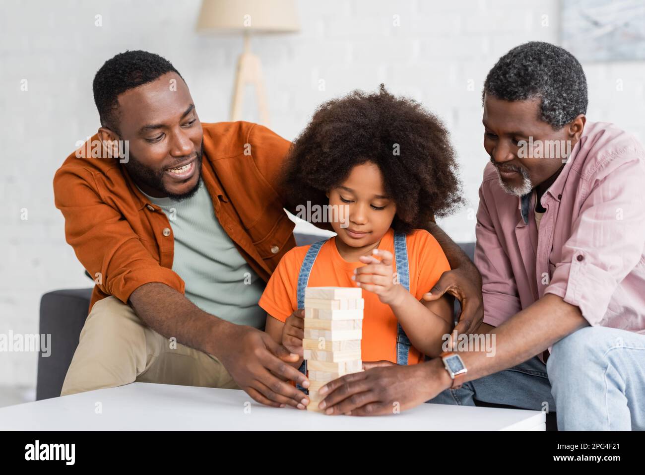 Cheerful african american father and grandpa playing wood blocks game ...