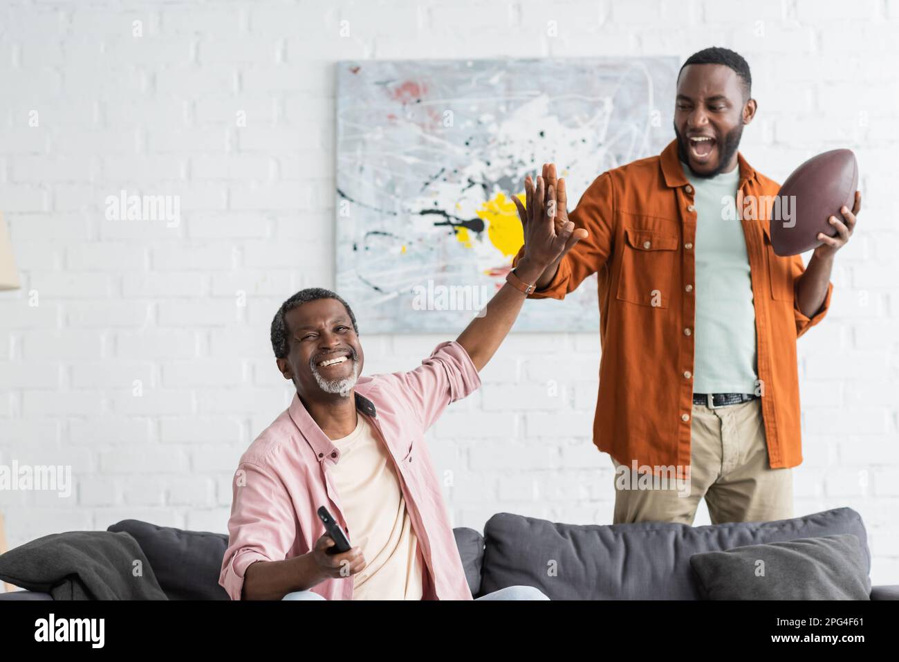 Positive african american father and son giving high five while ...