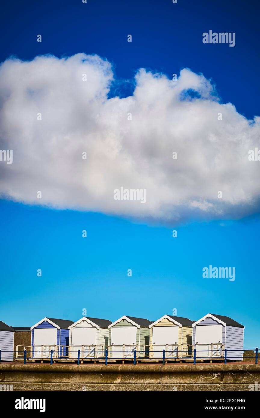 Large white cumulus cloud floating above beach huts Stock Photo - Alamy