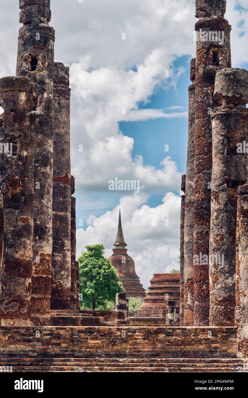 An aged temple stands in the sun, its weathered stone columns and ...