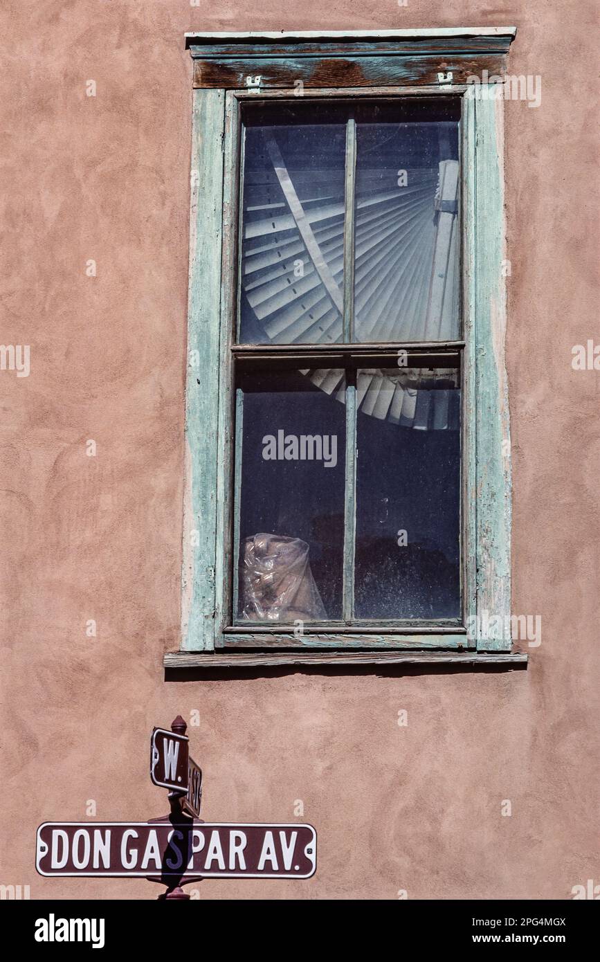 old weathered window with broken arced blinds and faded painted green ...