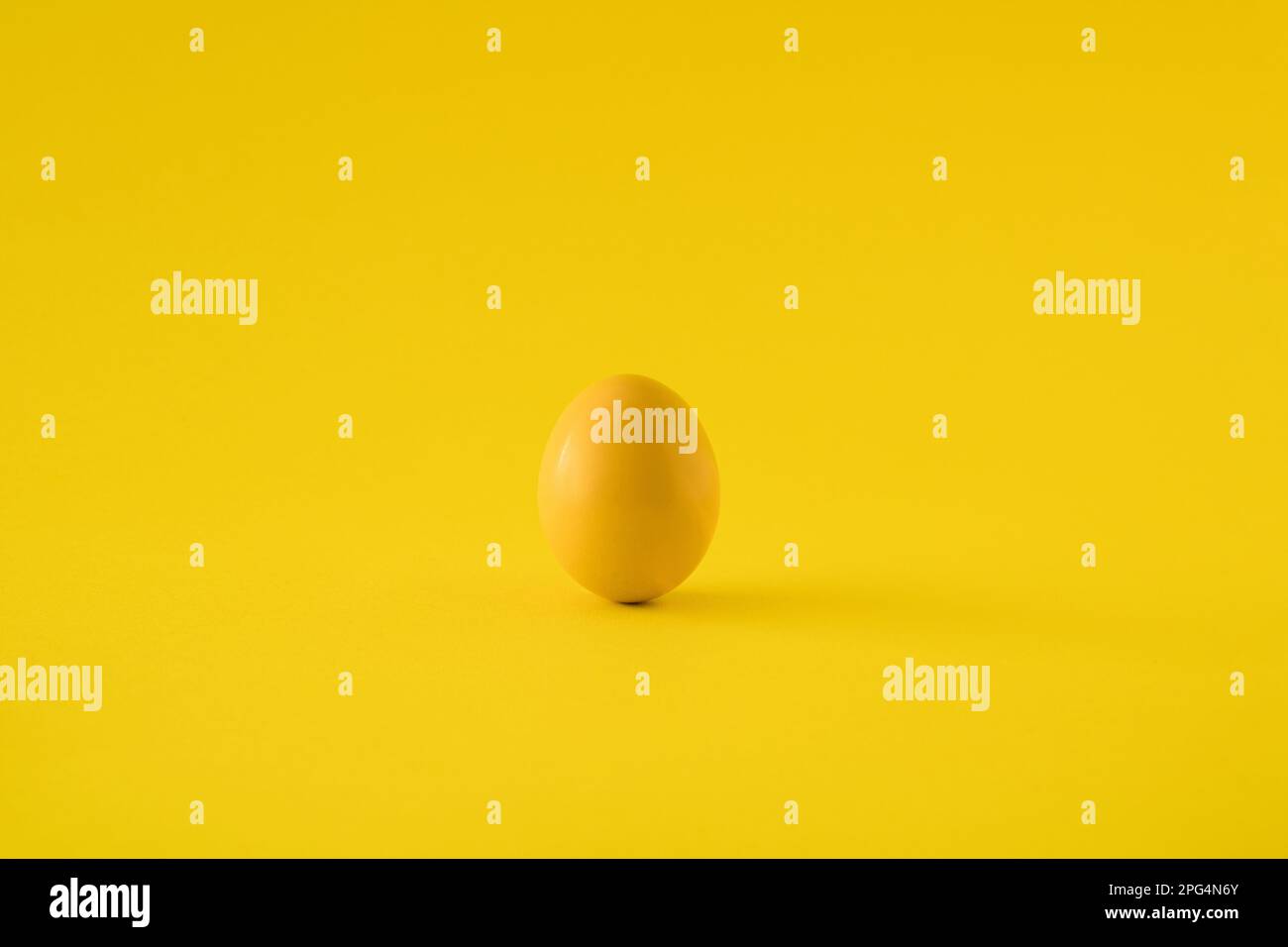 Yellow coloured egg on yellow background. Minimal Easter concept Stock ...