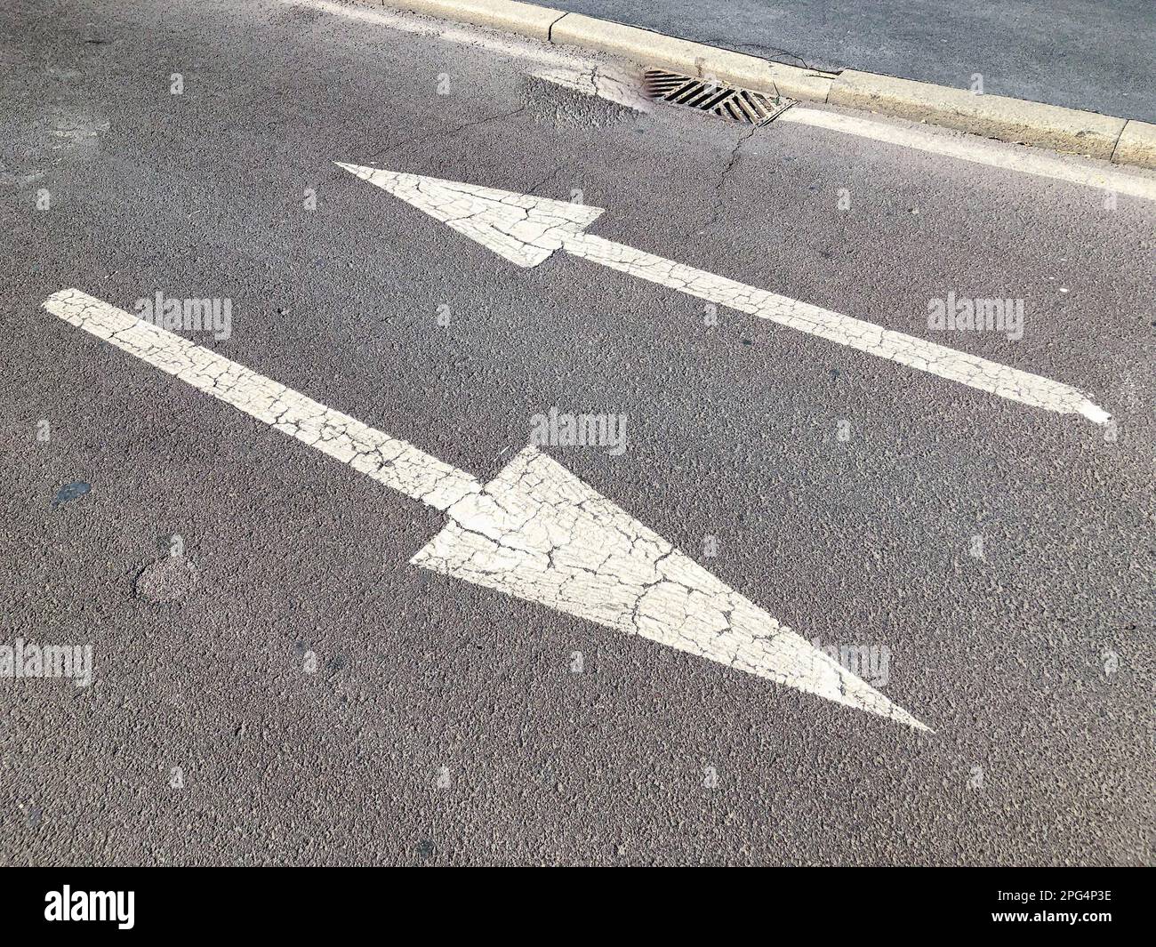 White arrows in the opposite direction on an asphalt urban road ...