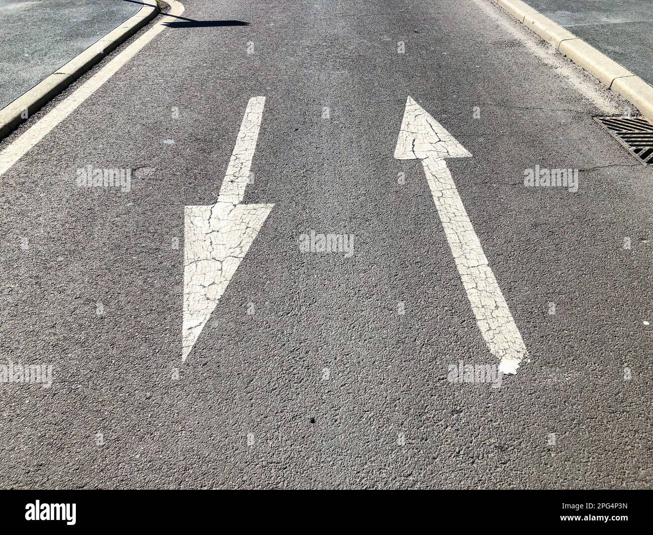 White arrows in the opposite direction on an asphalt urban road ...