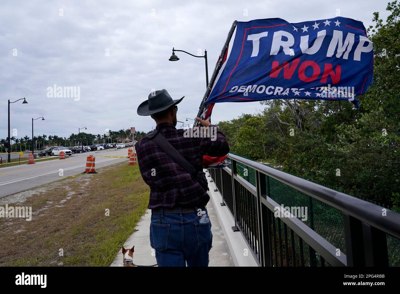 A supporter of former President Donald Trump walks across the bridge ...