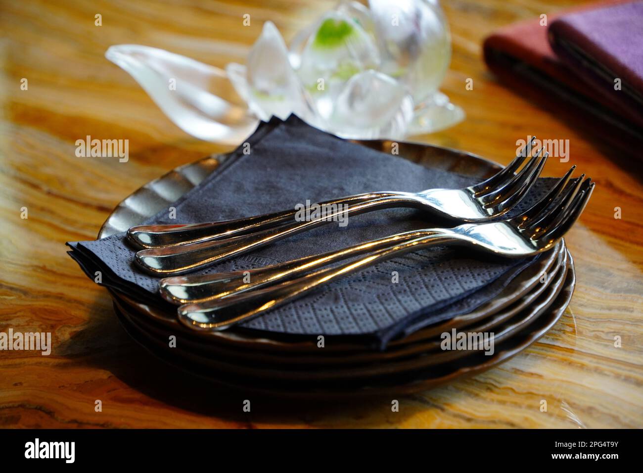 A stylish arrangement of four white plates with forks on top of them ...