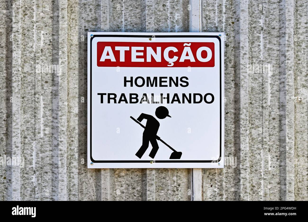 Metal sign indicating MEN AT WORK with words in Portuguese Stock Photo ...