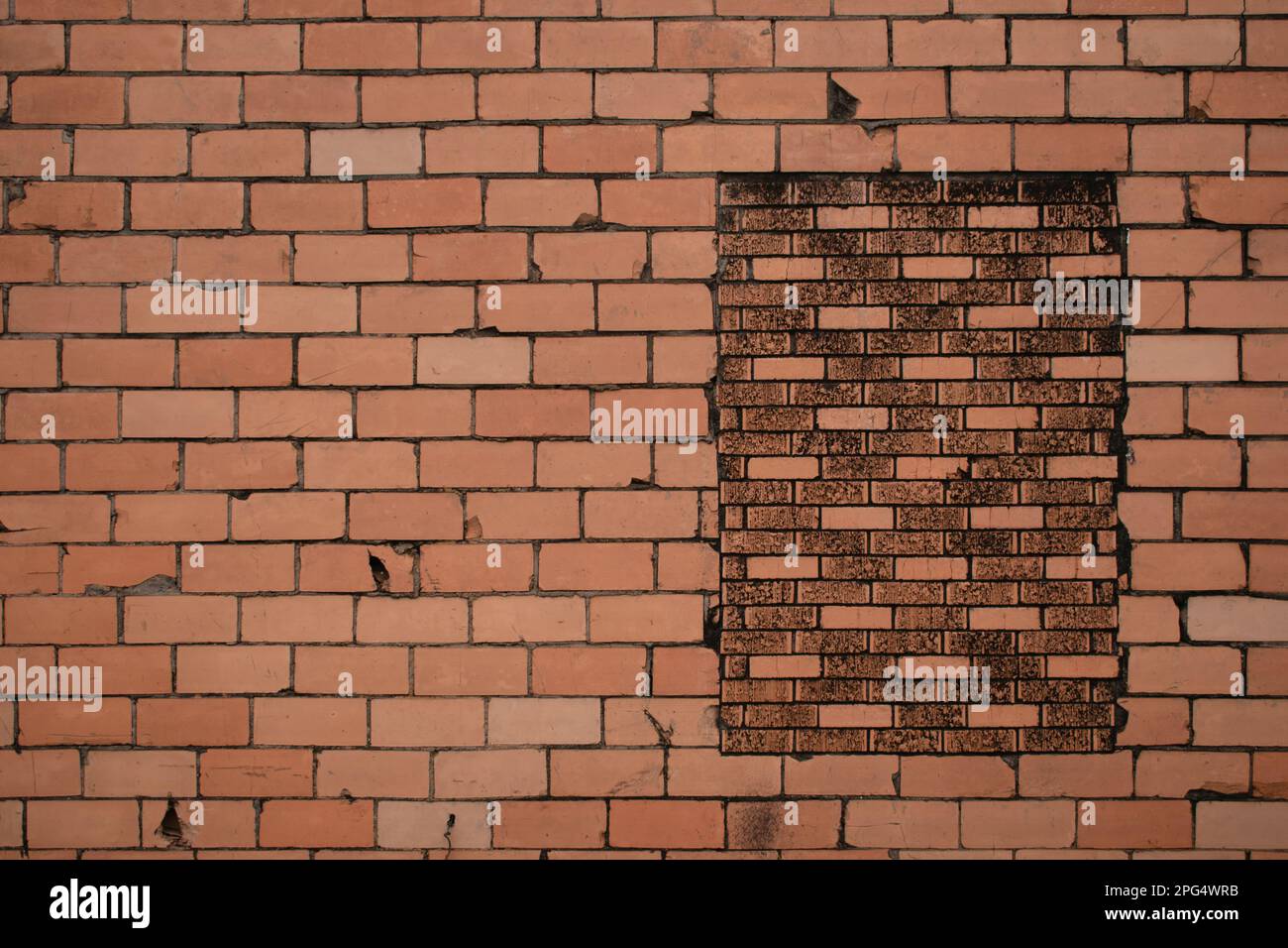 Brown brick wall black brick patched window Stock Photo - Alamy