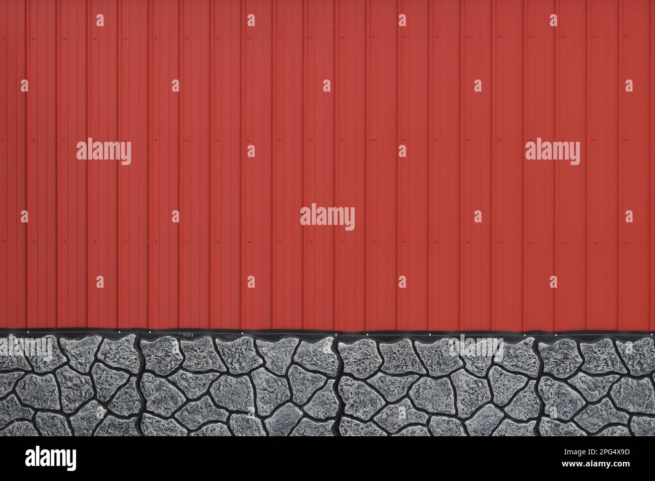 Red warehouse siding with faux rock detail Stock Photo - Alamy