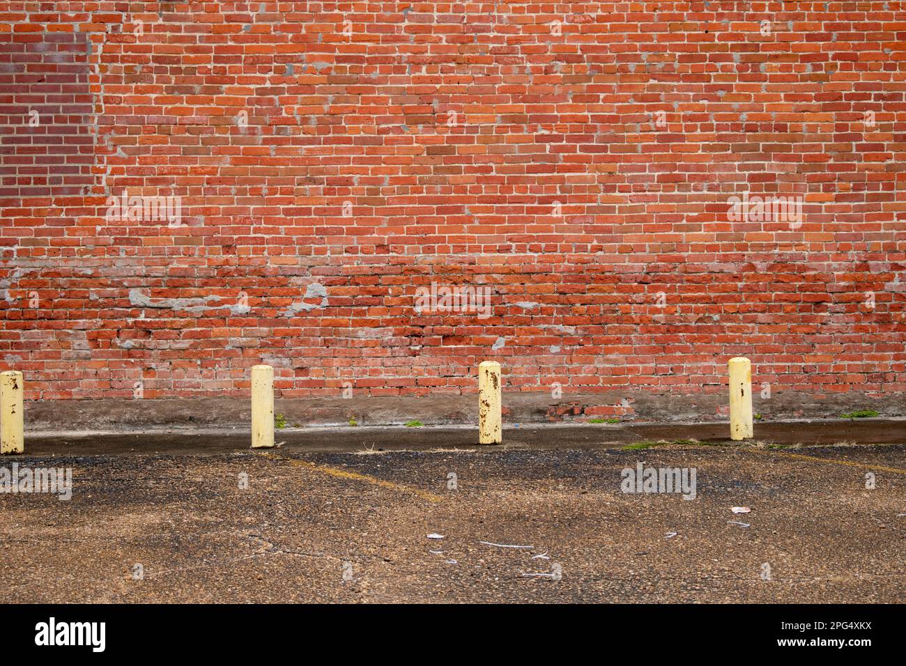Vintage brick and mortar background parking lot yellow bollards Stock ...