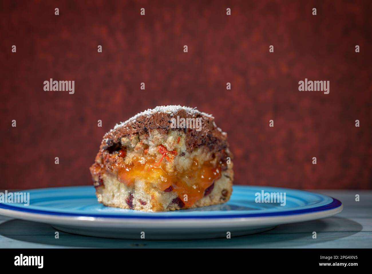 Vegan chocolate apricose cake with dry cranberry on blue dish and dark ...