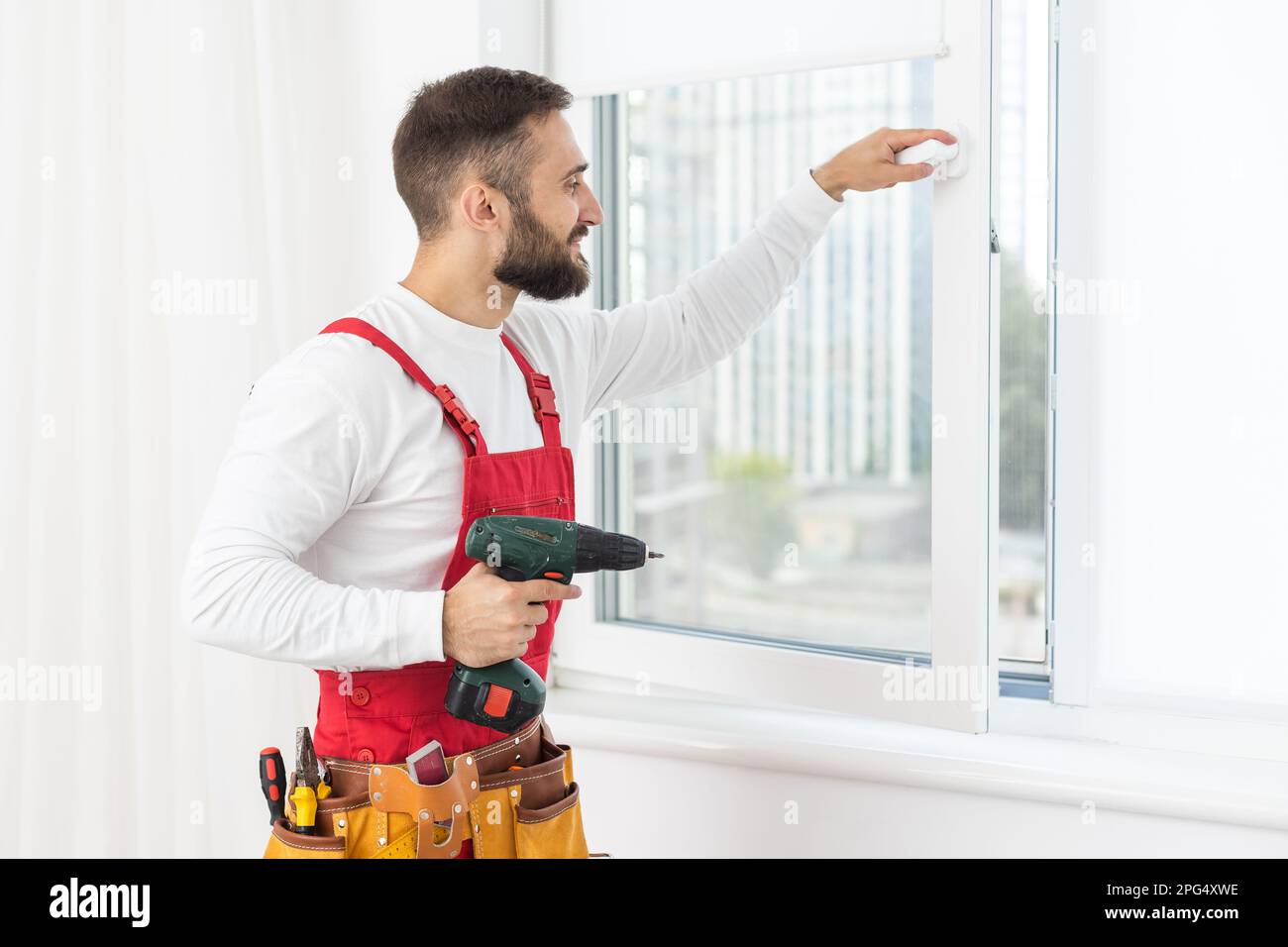 service man installing window with screwdriver Stock Photo - Alamy