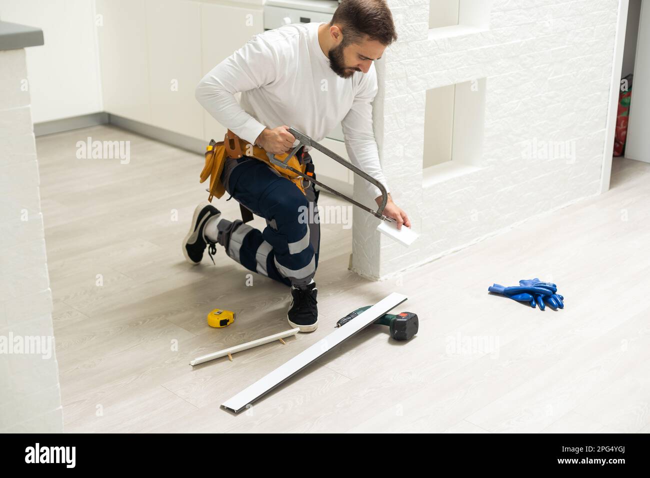 The craftsman measures the length of the plinth for cutting, installing ...