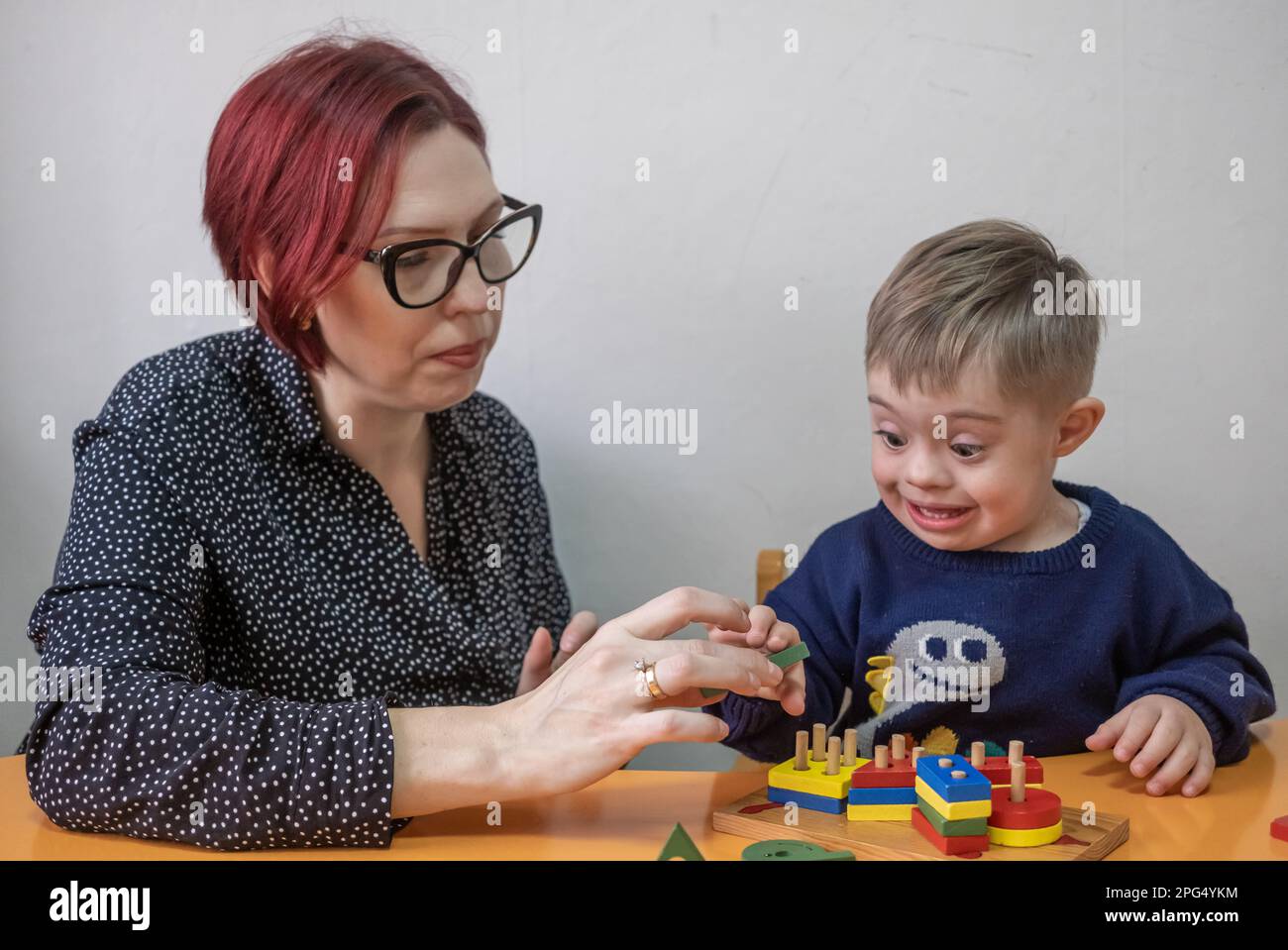 Child living with down syndrome playin. learning game with educational ...