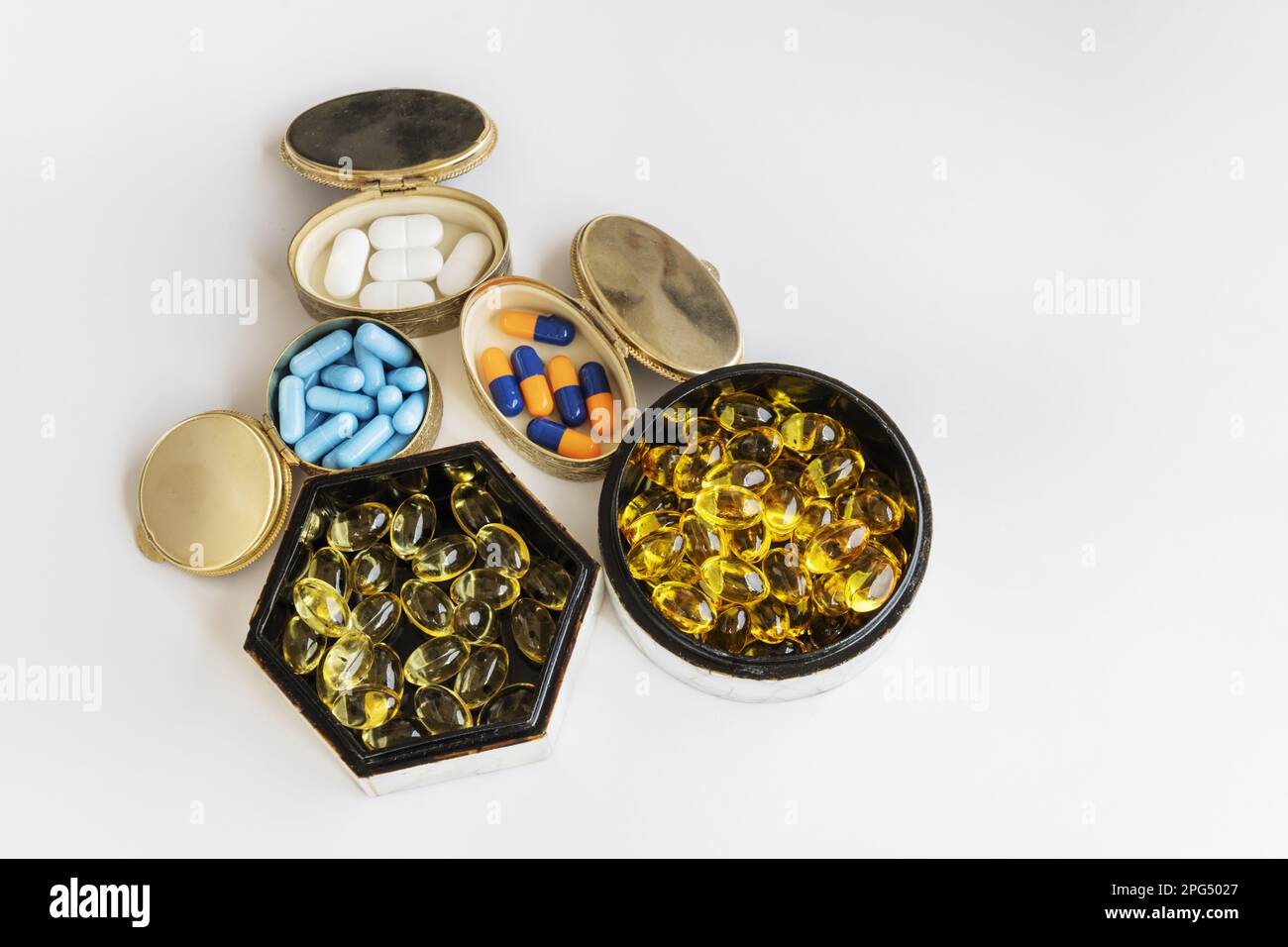 Pills of all kinds in small metal and plastic containers on a plain ...