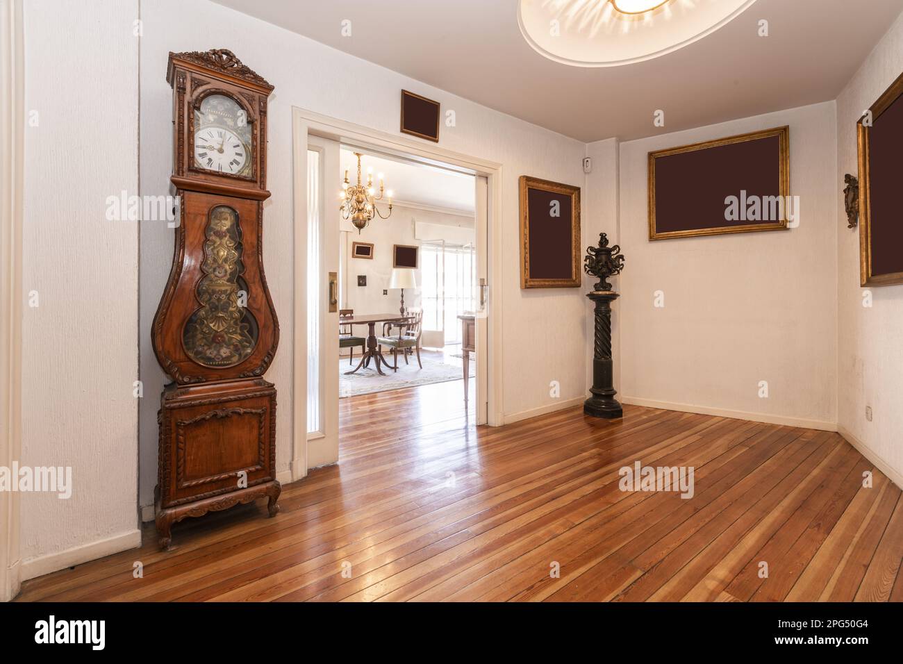 hall of a house with beautiful long-plank wooden floors, a grandfather ...