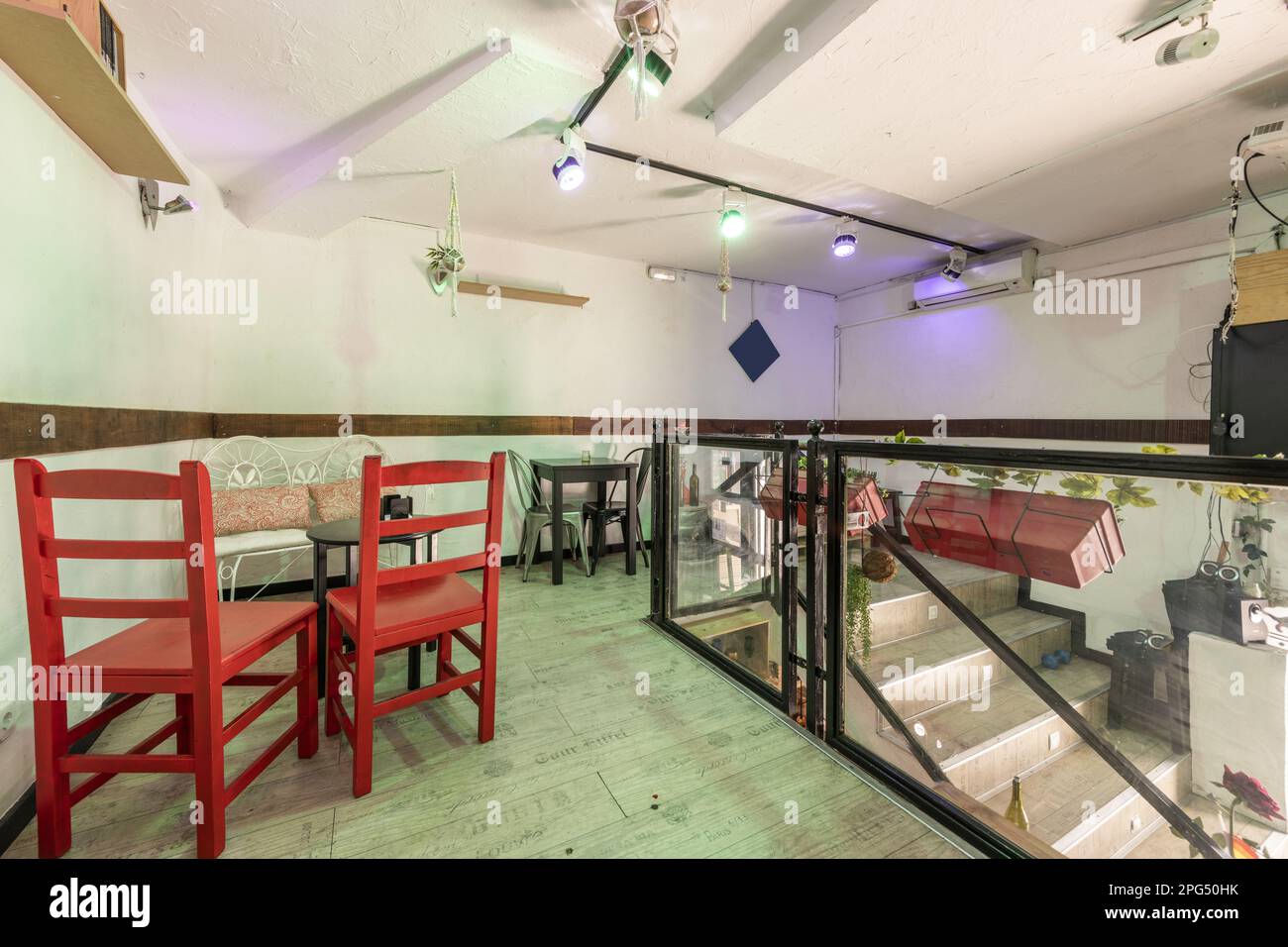 Mezzanine of a bar with a number of dining tables with chairs next to a ...