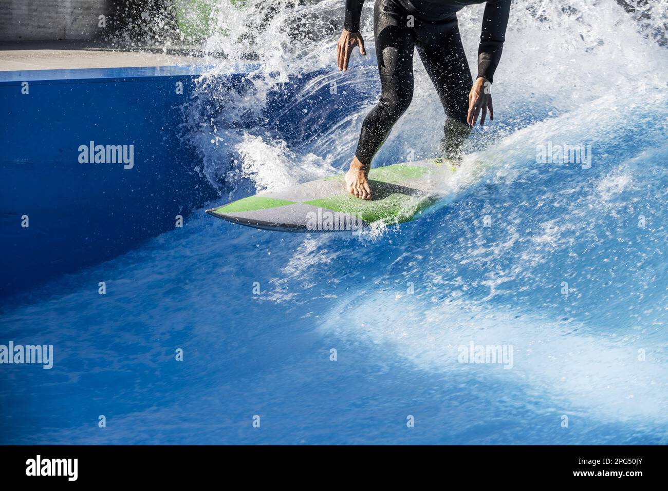 A surfer dressed in his black neoprene suit raising foam in the waves ...