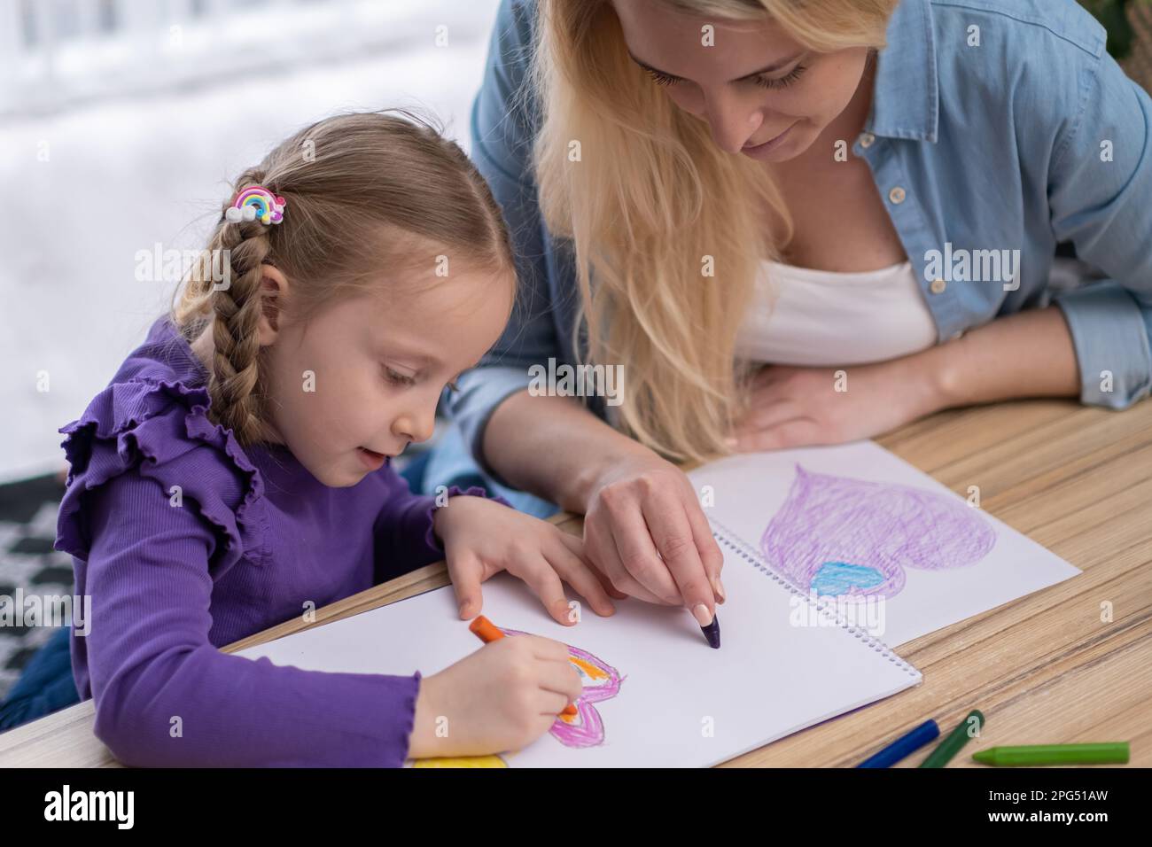 mother and daughter drawing and coloringheart shapes on paper. mom ...
