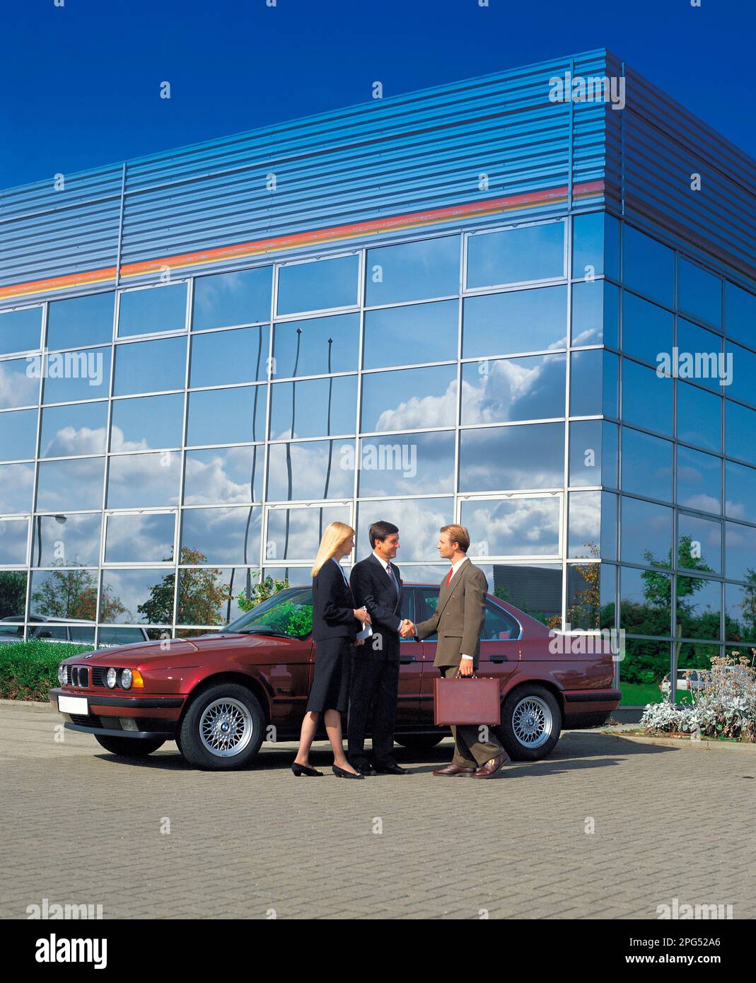 Business executives standing outside modern commercial building with ...