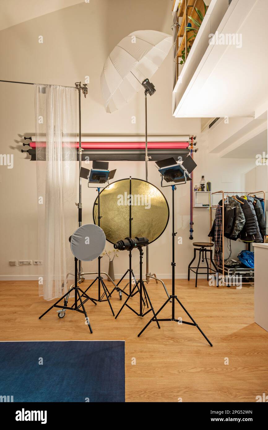 Photography studio full of lamps, backgrounds, umbrellas, diffusers ...
