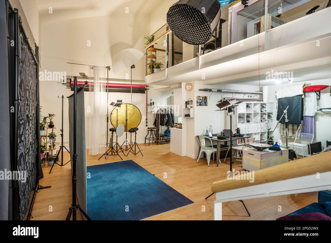Photography studio full of lamps, backdrops, umbrellas, diffusers ...