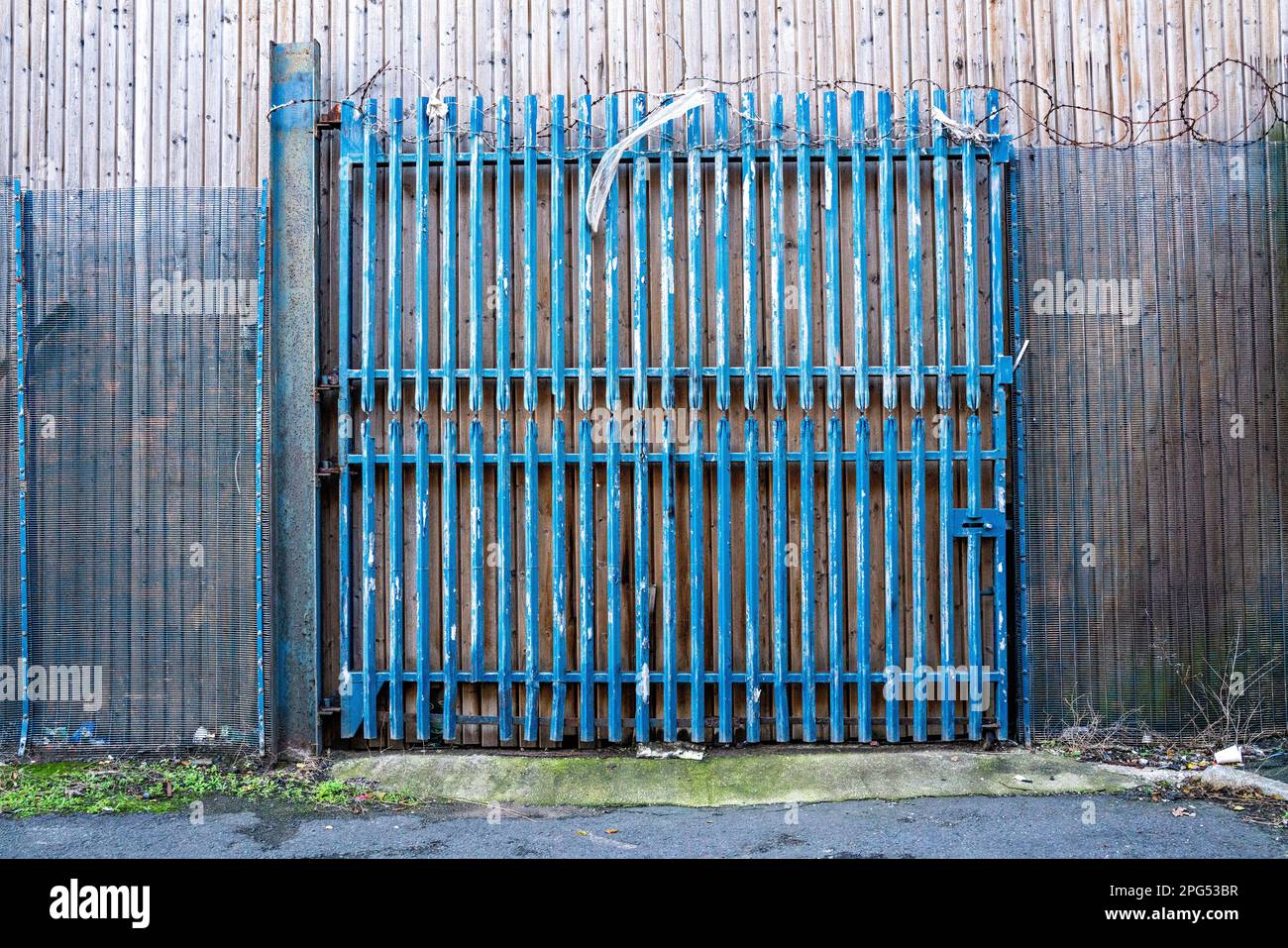 Redundant blue painted metal gate Stock Photo - Alamy