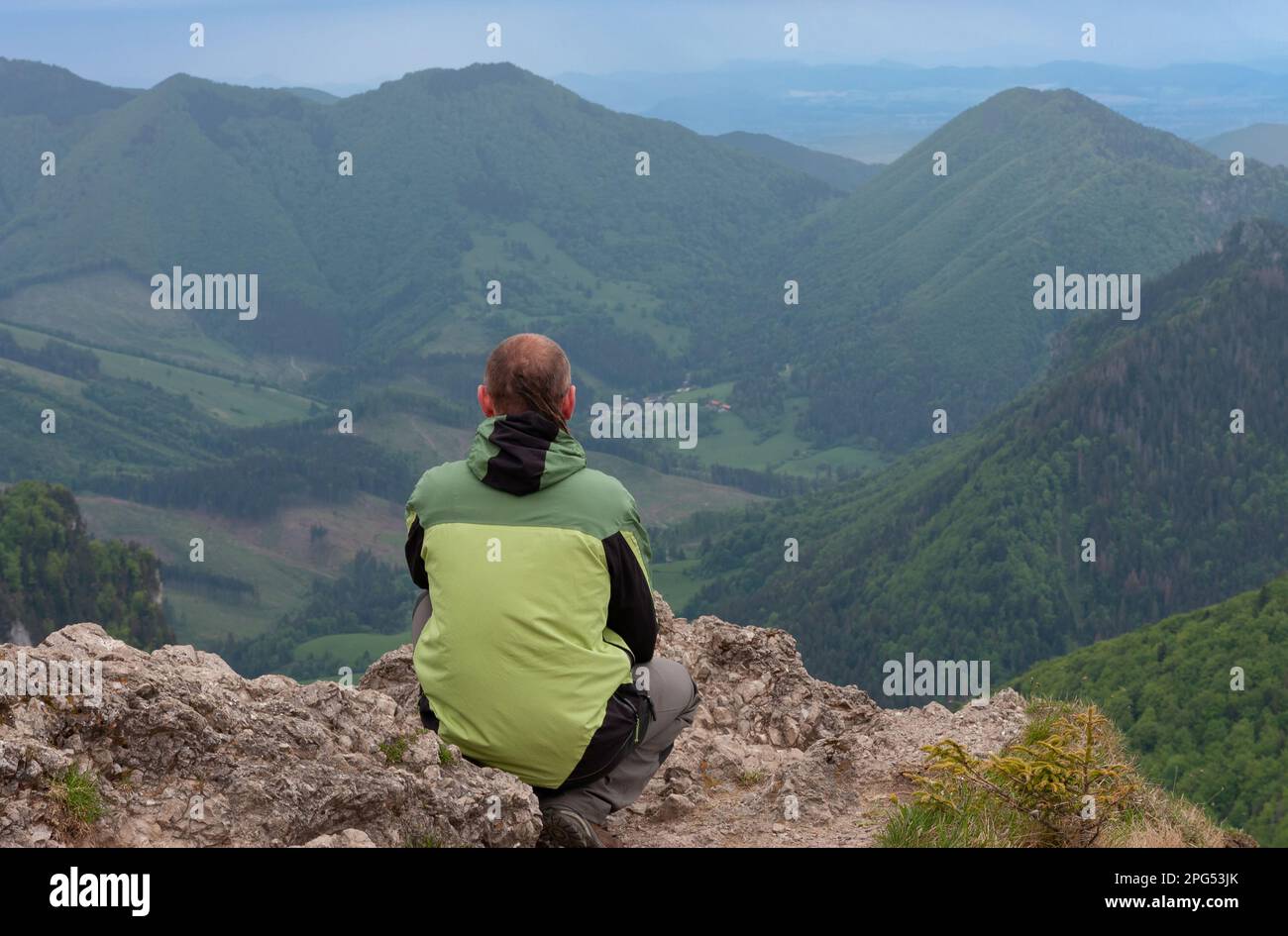 Hiker with dreadlocks on Maly Rozsutec, on background mountain village ...