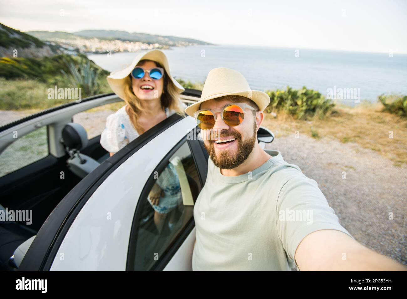 Happy beautiful couple in love taking a selfie portrait driving a ...
