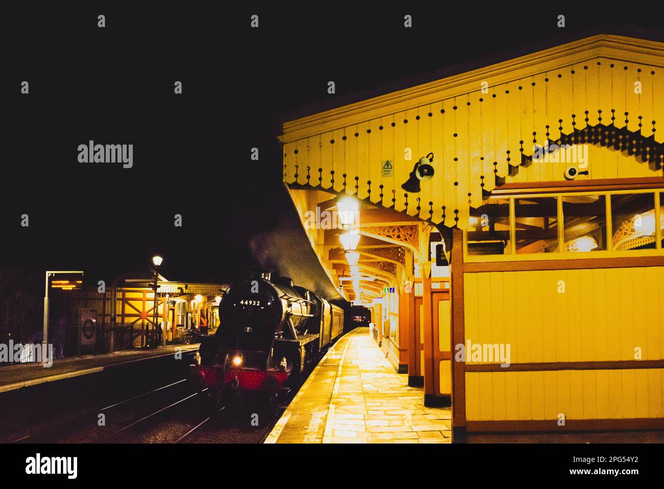 A Black 5 steam locomotive, pulling one carriage, going west through ...