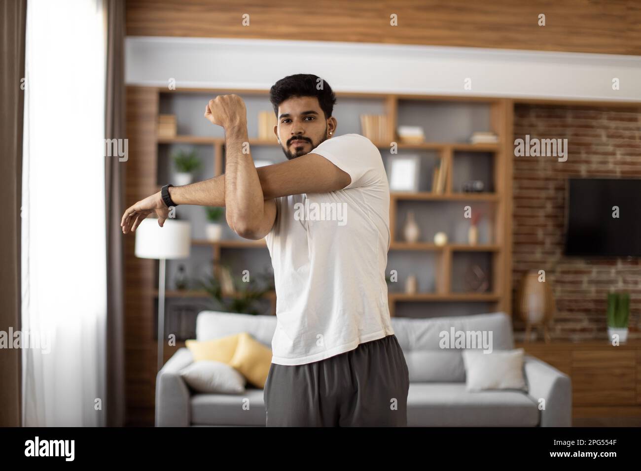 Handsome focused indian man stretching arms for bodybuilder fitness and ...