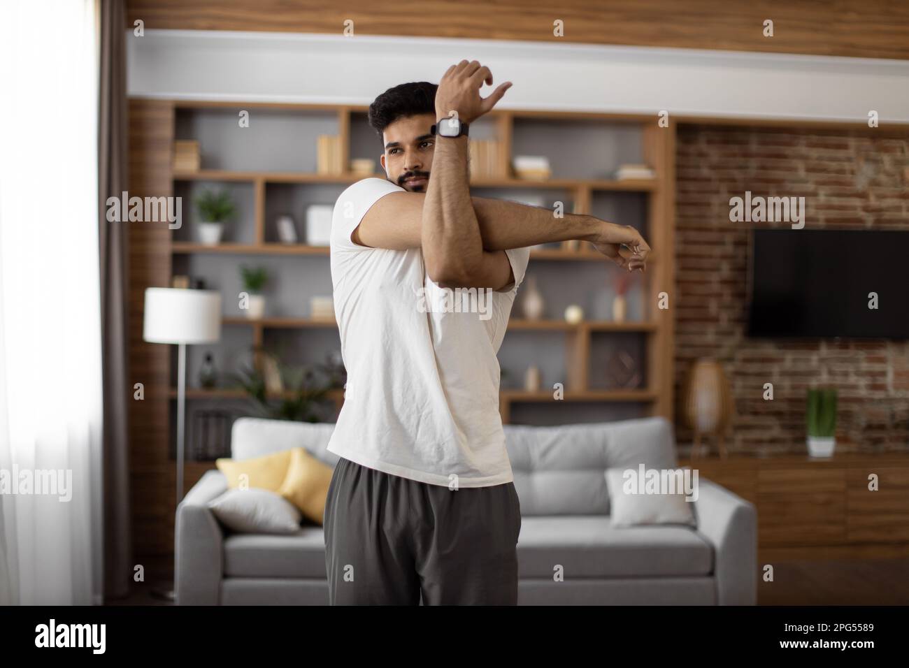Handsome focused indian man stretching arms for bodybuilder fitness and ...