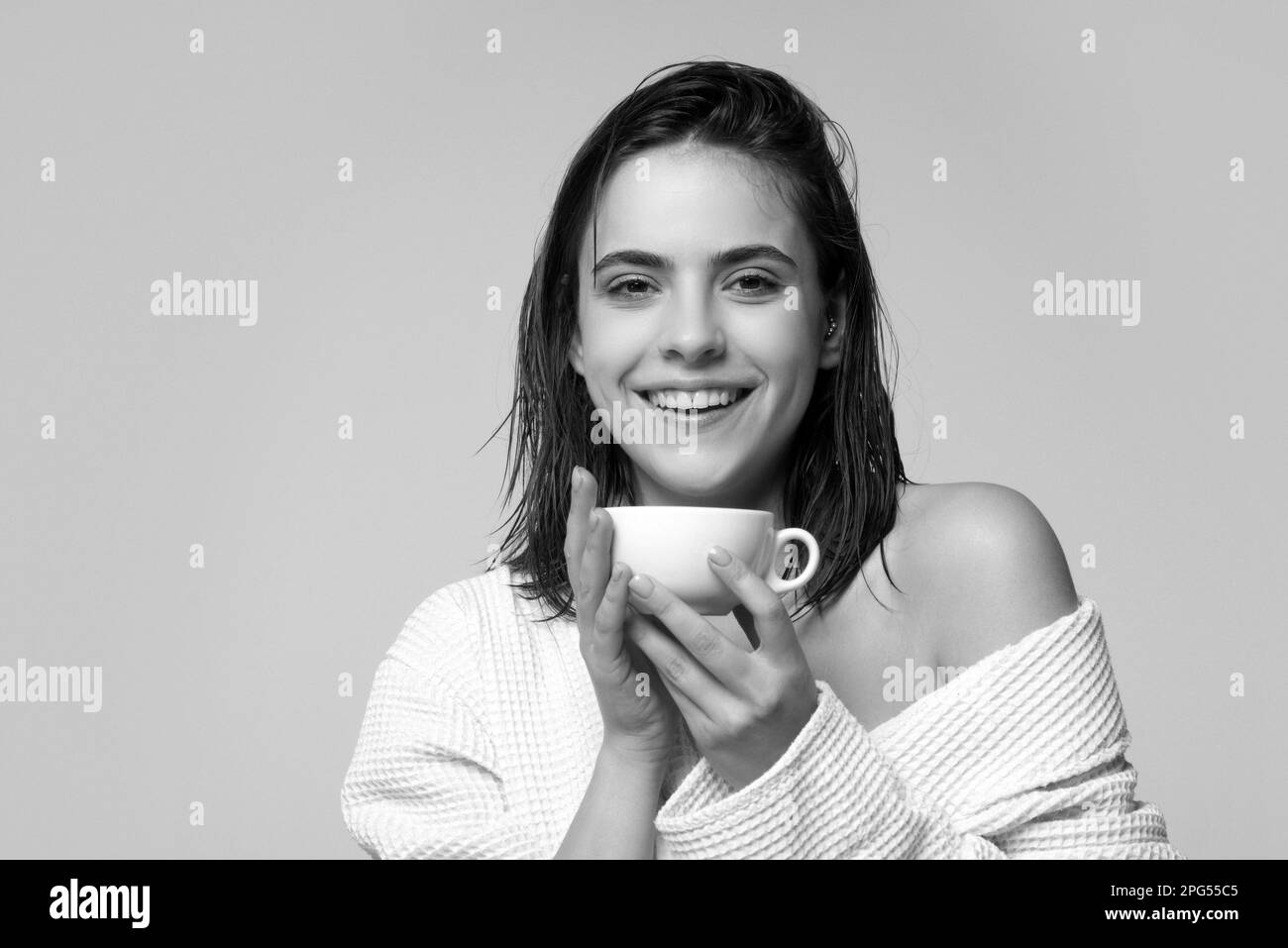 Female model holding cup of coffee. Happy smiling woman in bathrobe ...