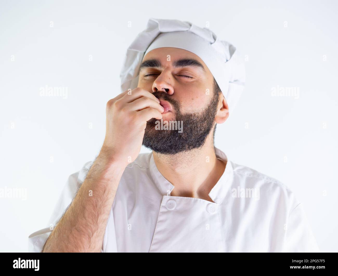 Young male chef doing a delicious gesture. Isolated on a white ...