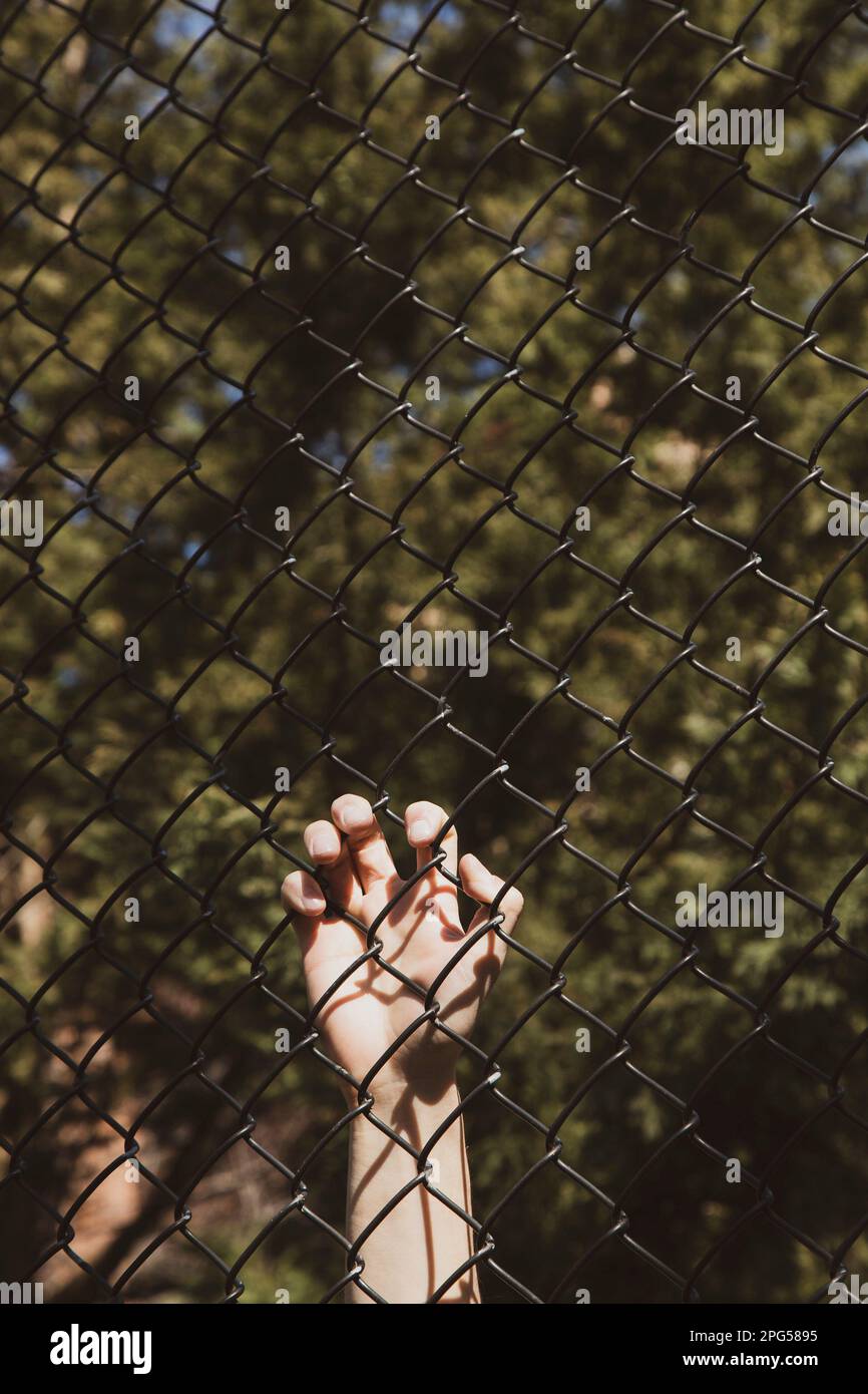 Hand holding black chain link fence at Anti-Asian Violence Rally, New ...