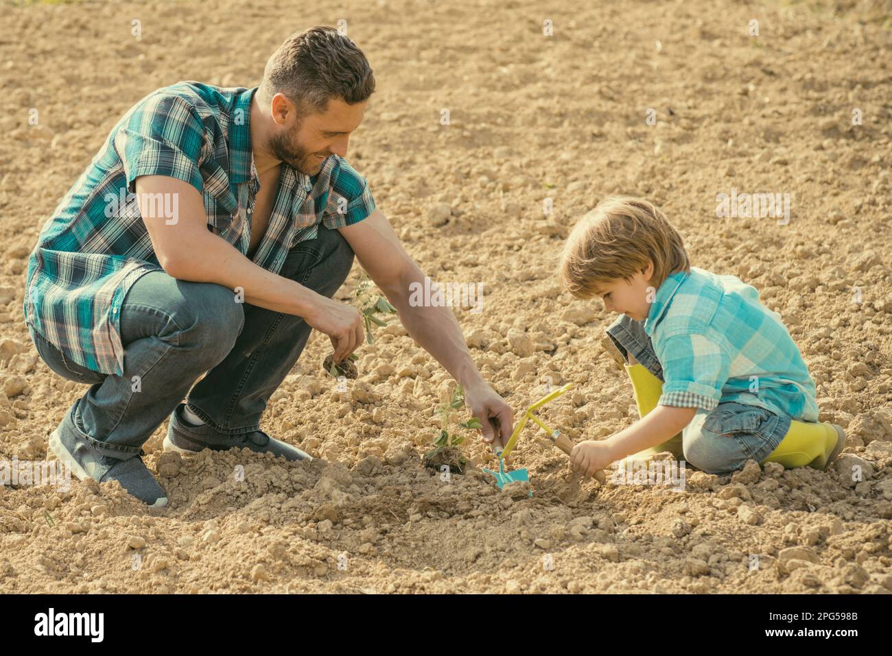 Father teaching his son gardening. Father and son work in garden Stock ...