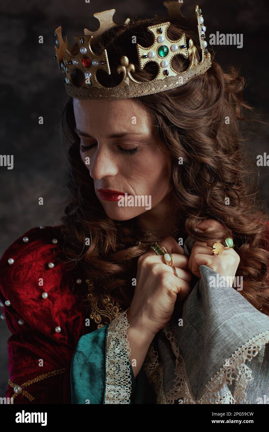 stressed medieval queen in red dress with handkerchief and crown on ...