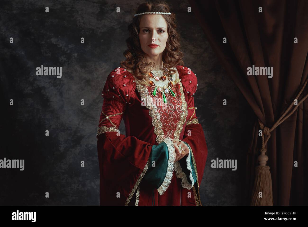 medieval queen in red dress on dark gray background Stock Photo - Alamy