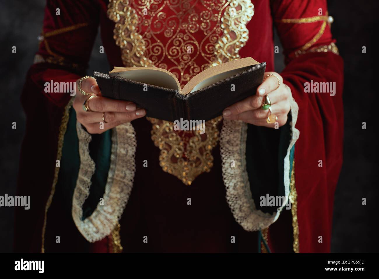 Closeup on medieval queen in red dress with book Stock Photo - Alamy