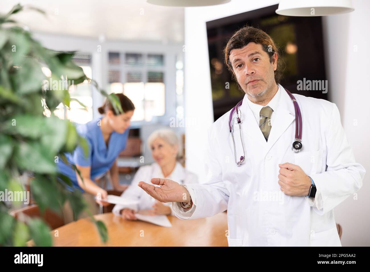 Friendly doctor invites you to visit clinic for diagnosis Stock Photo ...