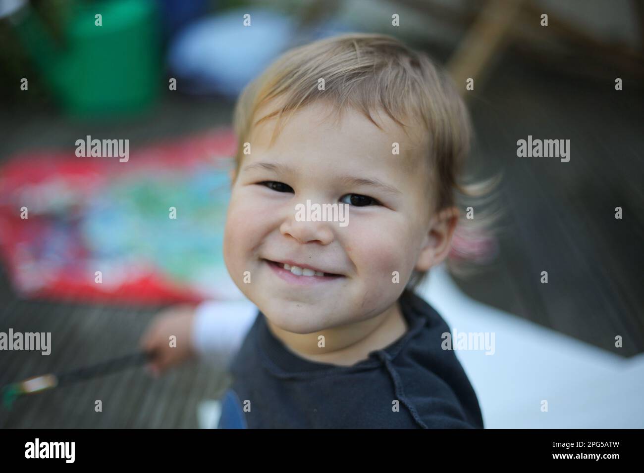 Happy baby sitting outdoors smiling Stock Photo - Alamy