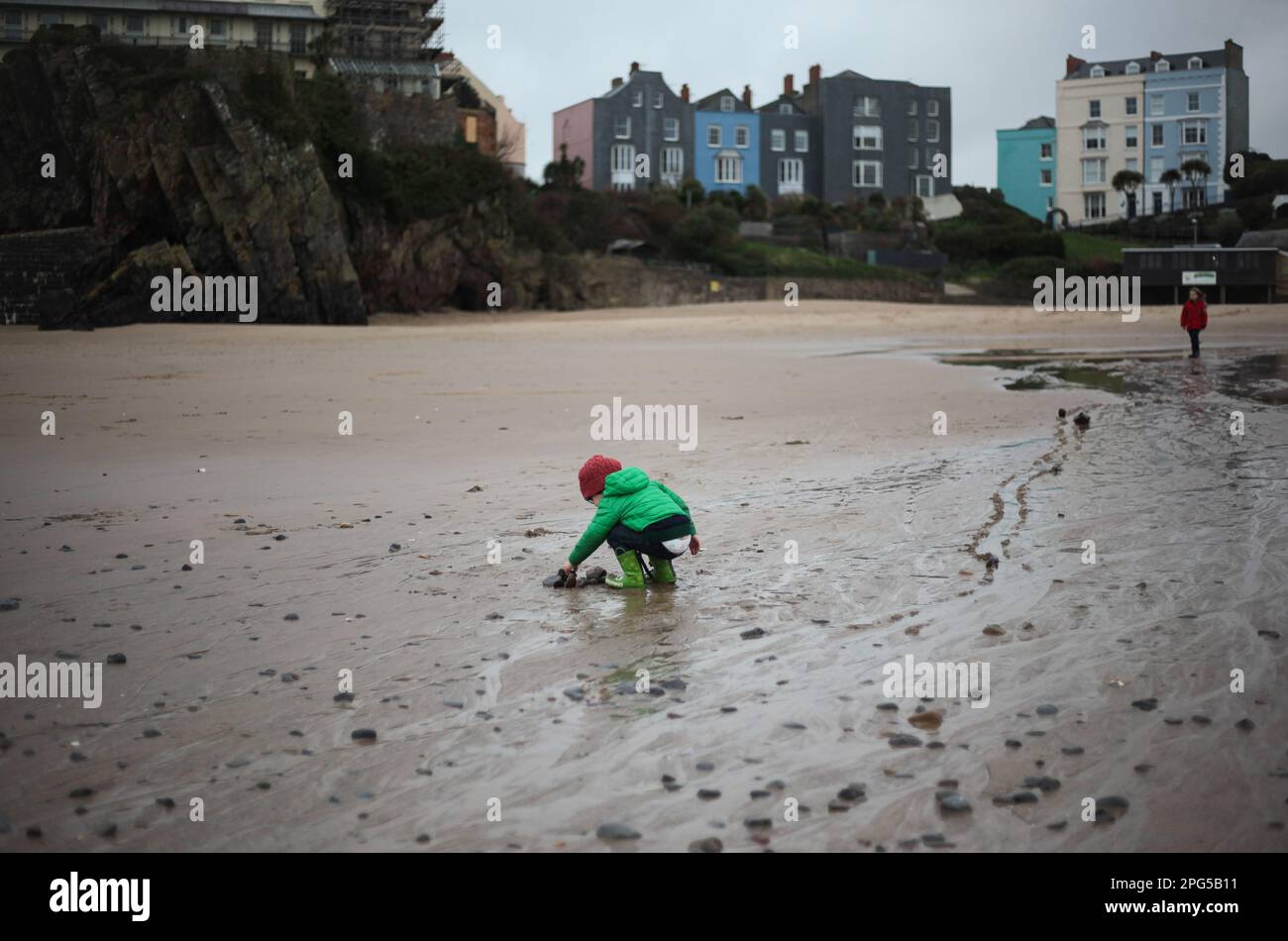 Child looking for seashells on the beach Stock Photo - Alamy