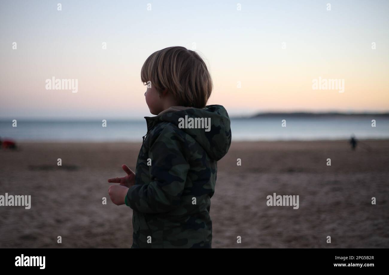 young boy watching the sunset on the beach, Tenby Stock Photo - Alamy