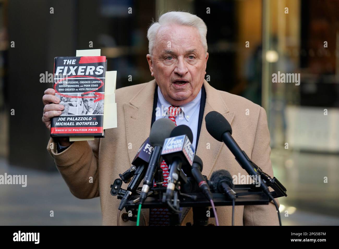 Attorney Bob Costello holds up a book while talking to reporters after ...